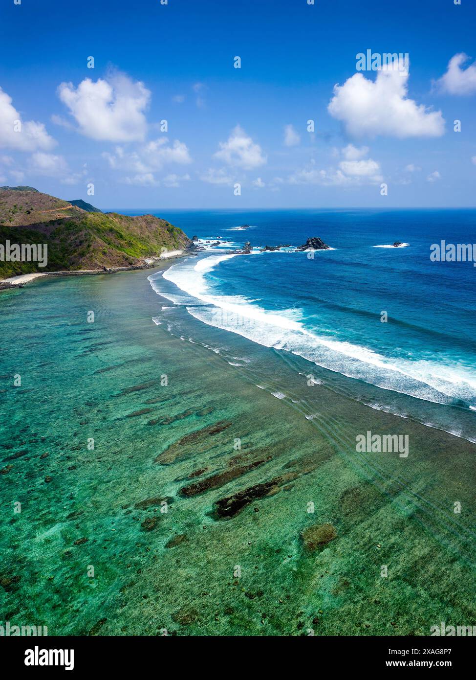 Aerial view of a deep, blue tropical ocean waves breaking over a large ...