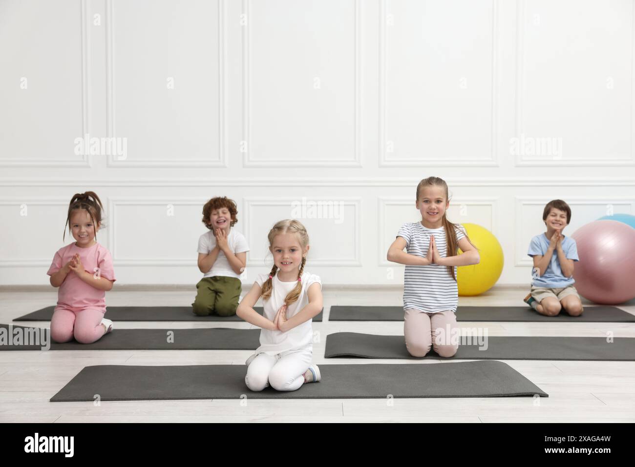 Group of children doing gymnastic exercises on mats indoors Stock Photo ...