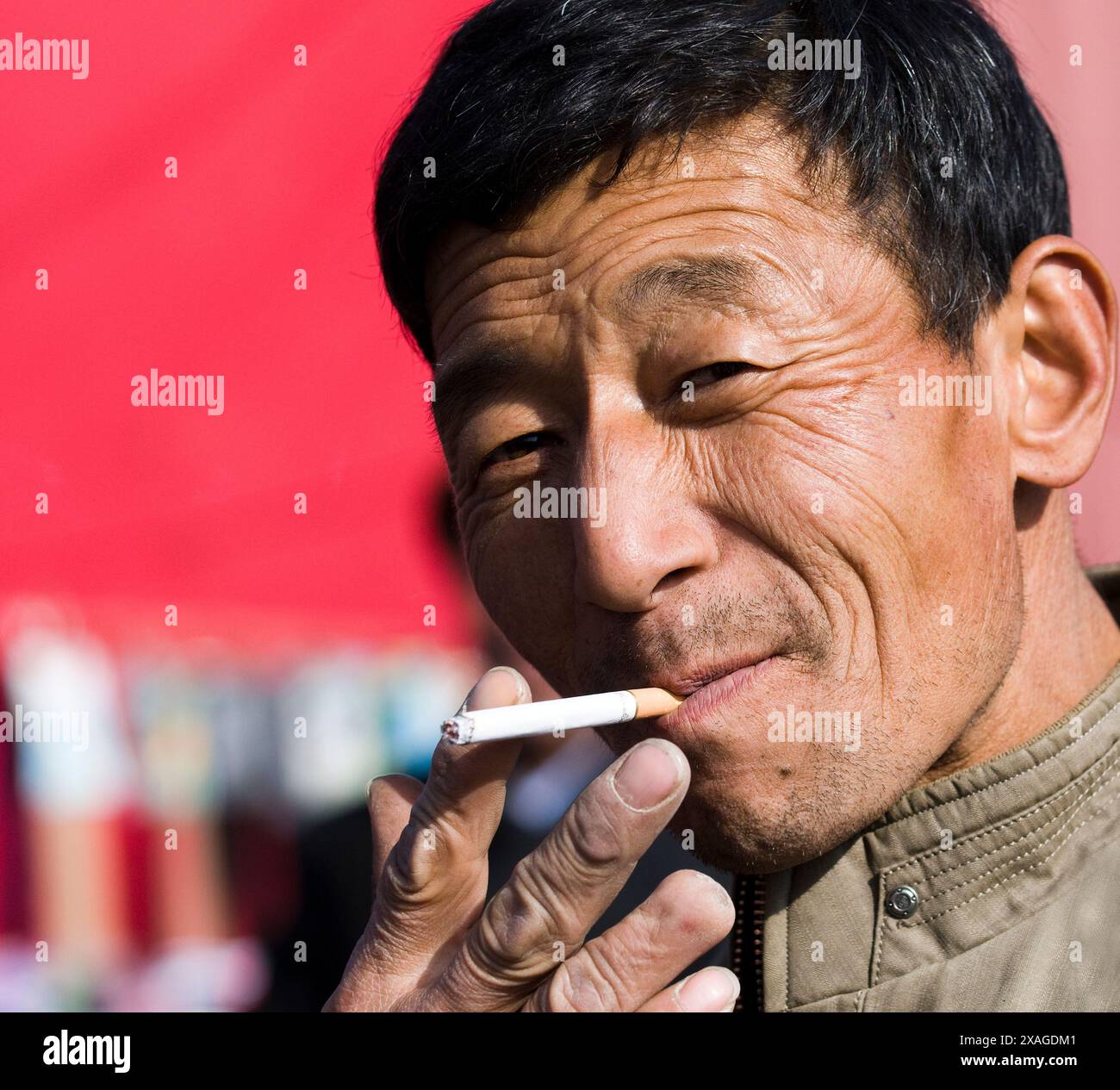 A Chinese man smoking his cigarette. Photo taken in Xinjiang, China ...