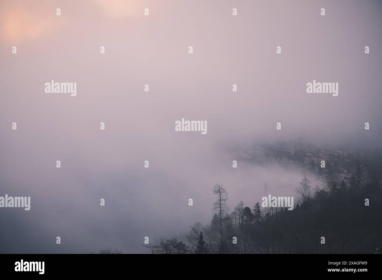 Orange sunrise sky at the rice terraces, dense fog and Duoyishu village ...