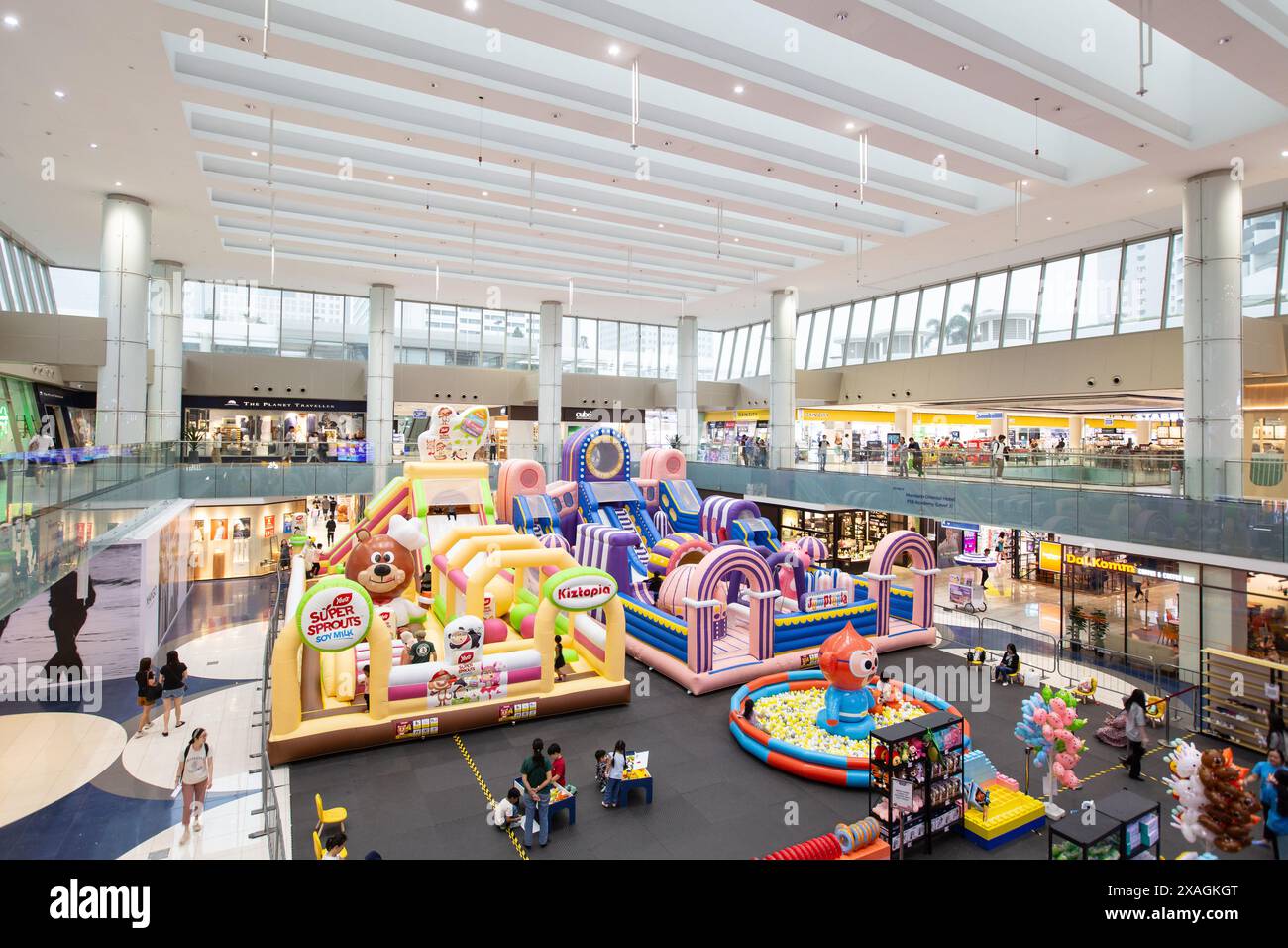 Inside a spacious shopping mall interior. A huge bouncy castle is set ...