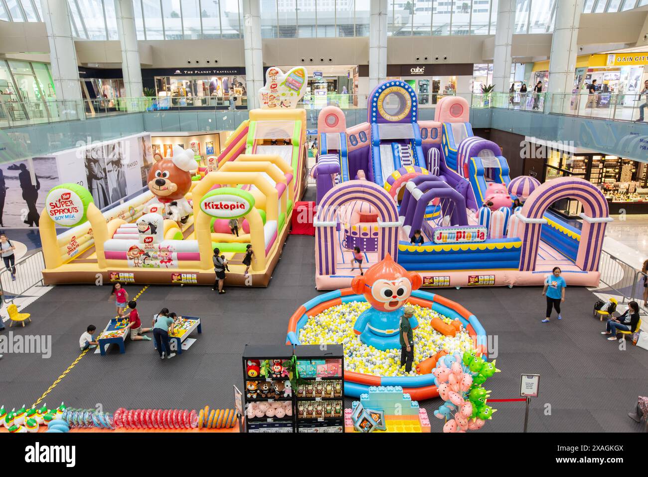Inside a spacious shopping mall interior. A huge bouncy castle is set ...