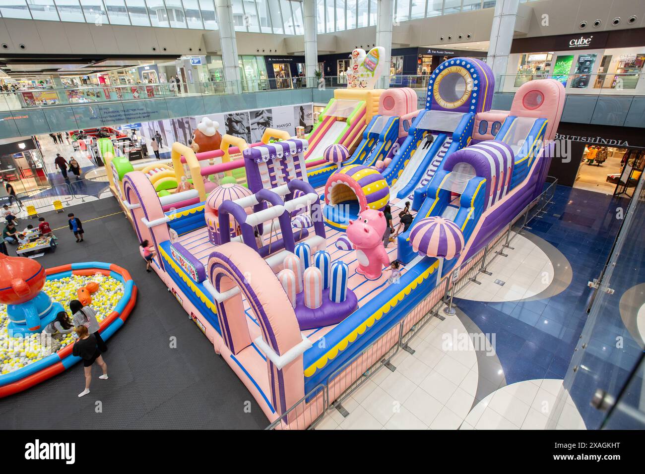 Inside a spacious shopping mall interior. A huge bouncy castle is set ...