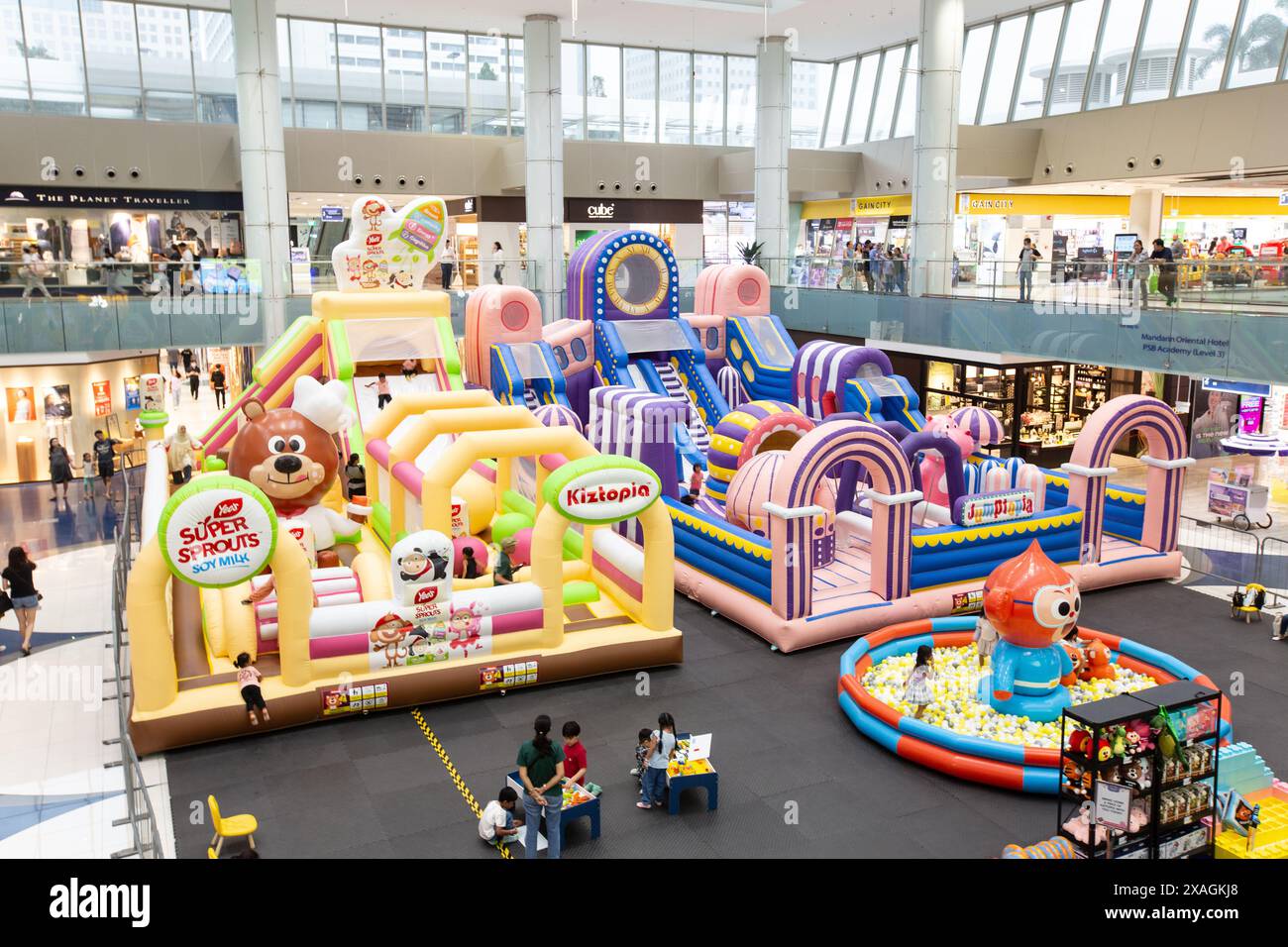 Inside a spacious shopping mall interior. A huge bouncy castle is set ...