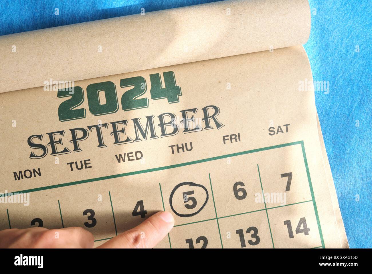 Hand pointing on September 5 2024 date on calendar flat lay in blue ...