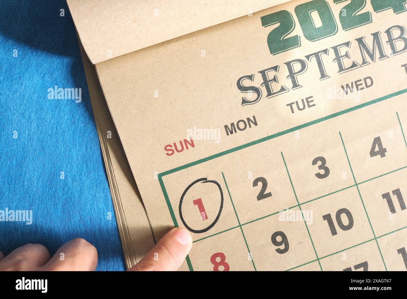 Hand pointing on September 1 2024 date on calendar flat lay in blue ...