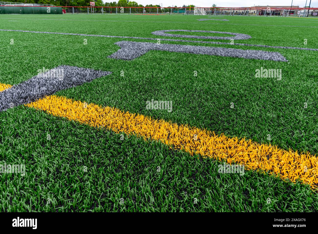Late afternoon close up photo of gray football line with yellow soccer ...
