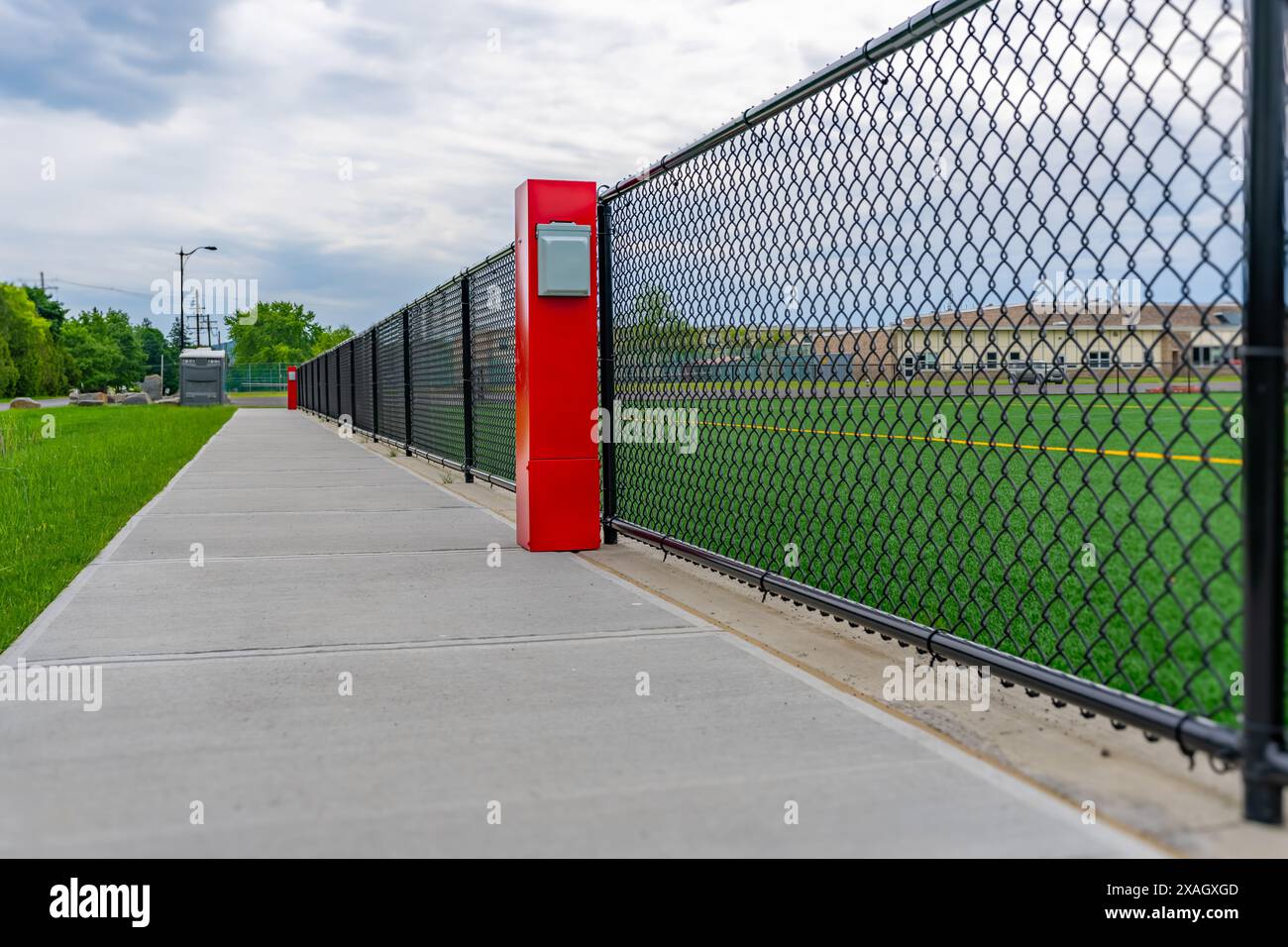Black chain link fence with a sports field in background Stock Photo ...