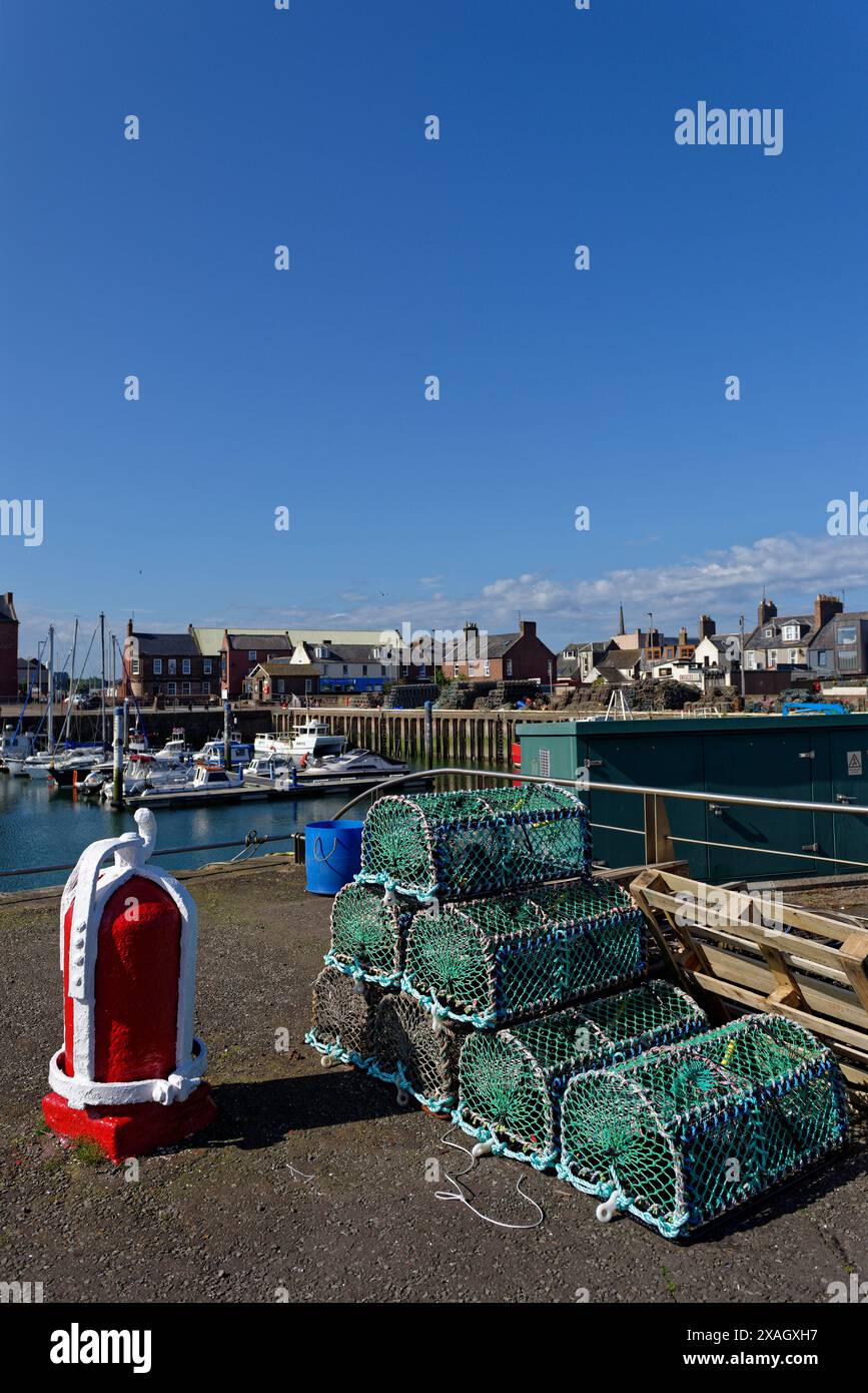 A traditional red painted old Bollard next to Lobster and Crab pots at ...