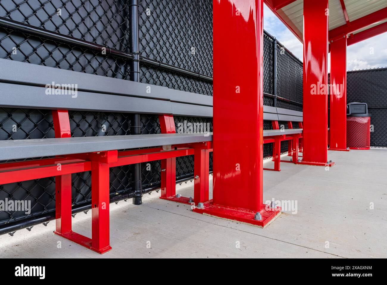 Interior photo of a red softball baseball dugout with roof, concrete ...
