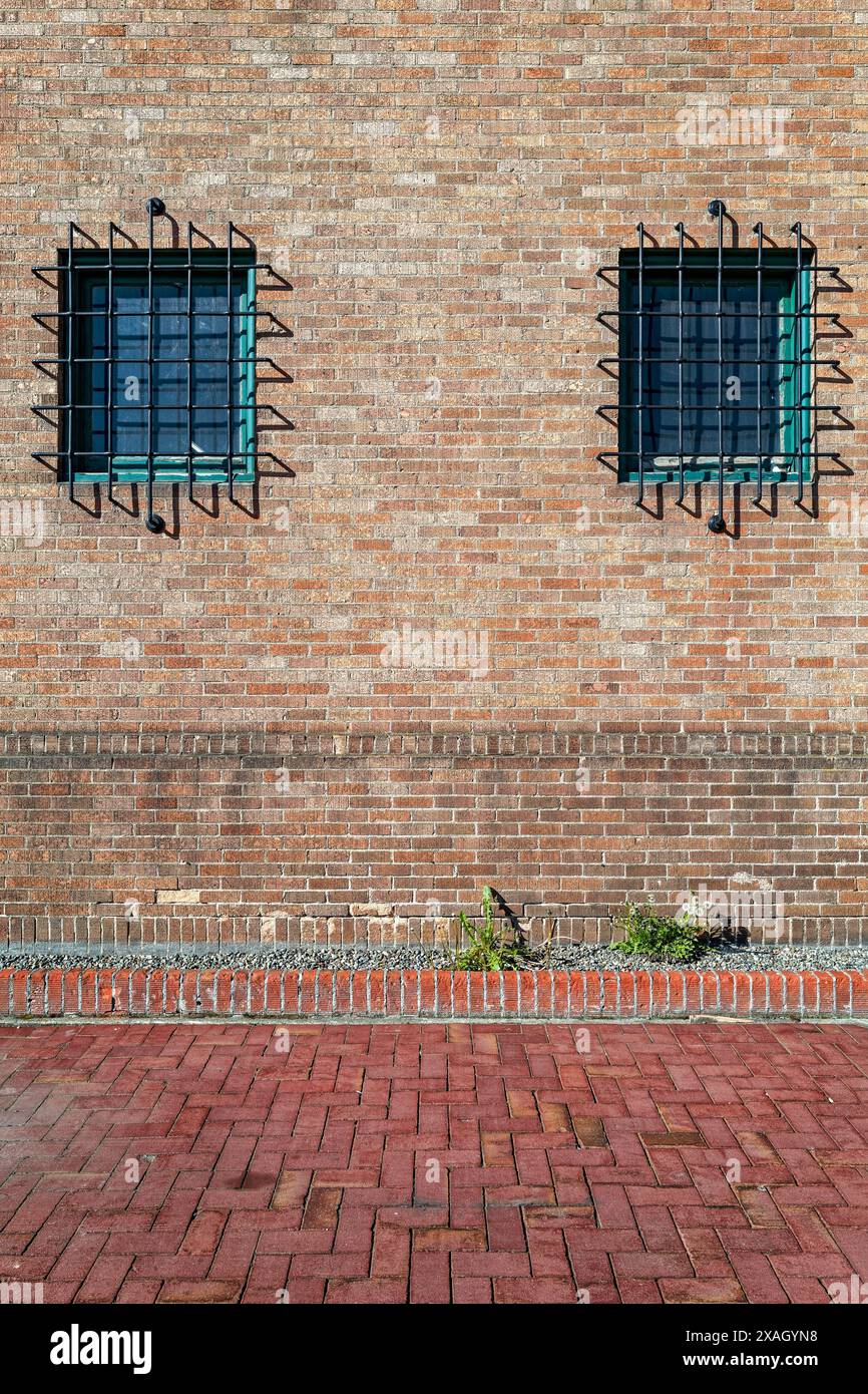 The barred windows on the exterior wall of an old brick building Stock ...