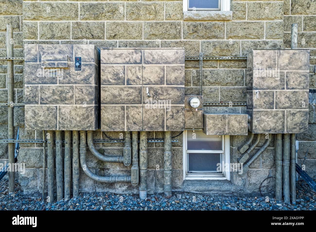 Outdoor electrical utility cabinets are painted to match the wall of an ...