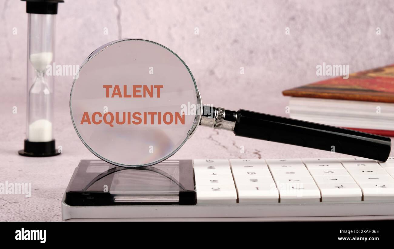 Business concept. TALENT ACQUISITION text through a magnifying glass on ...