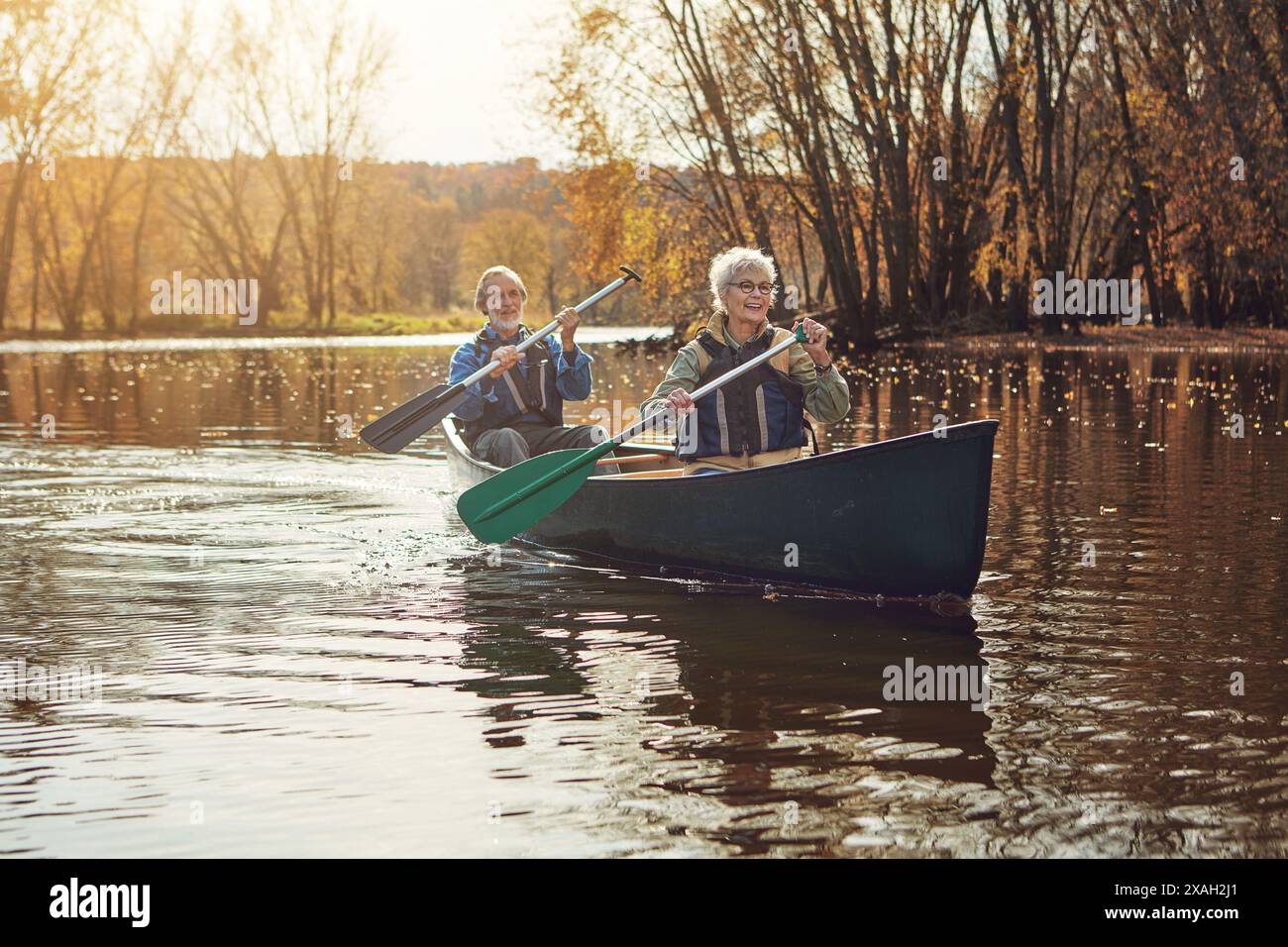 Senior couple, kayak and rowing in lake for holiday, travel or summer ...