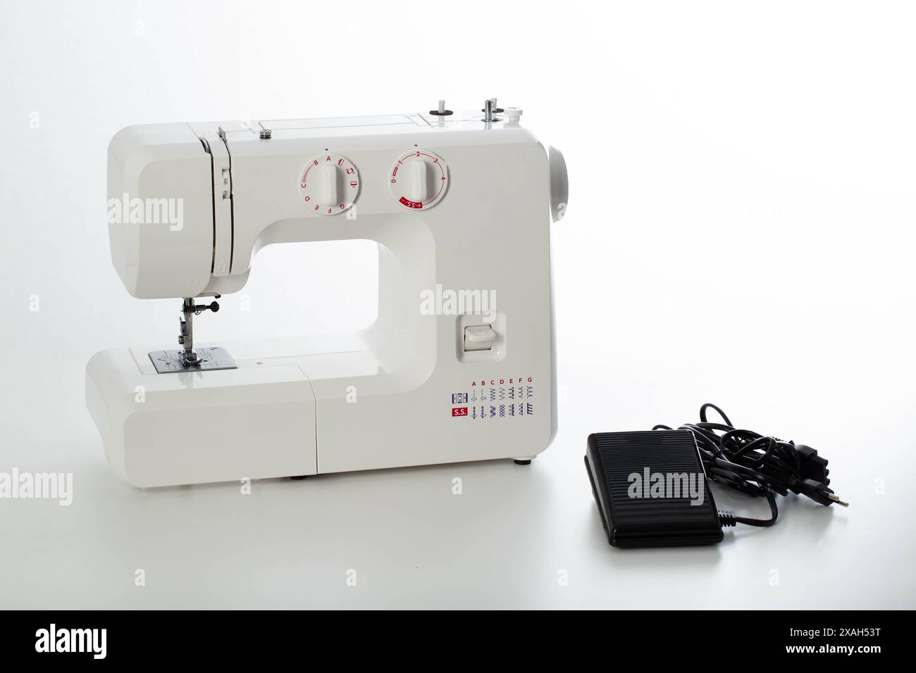 Automatic modern sewing machine with overlock and black pedal on a white background, isolate ...