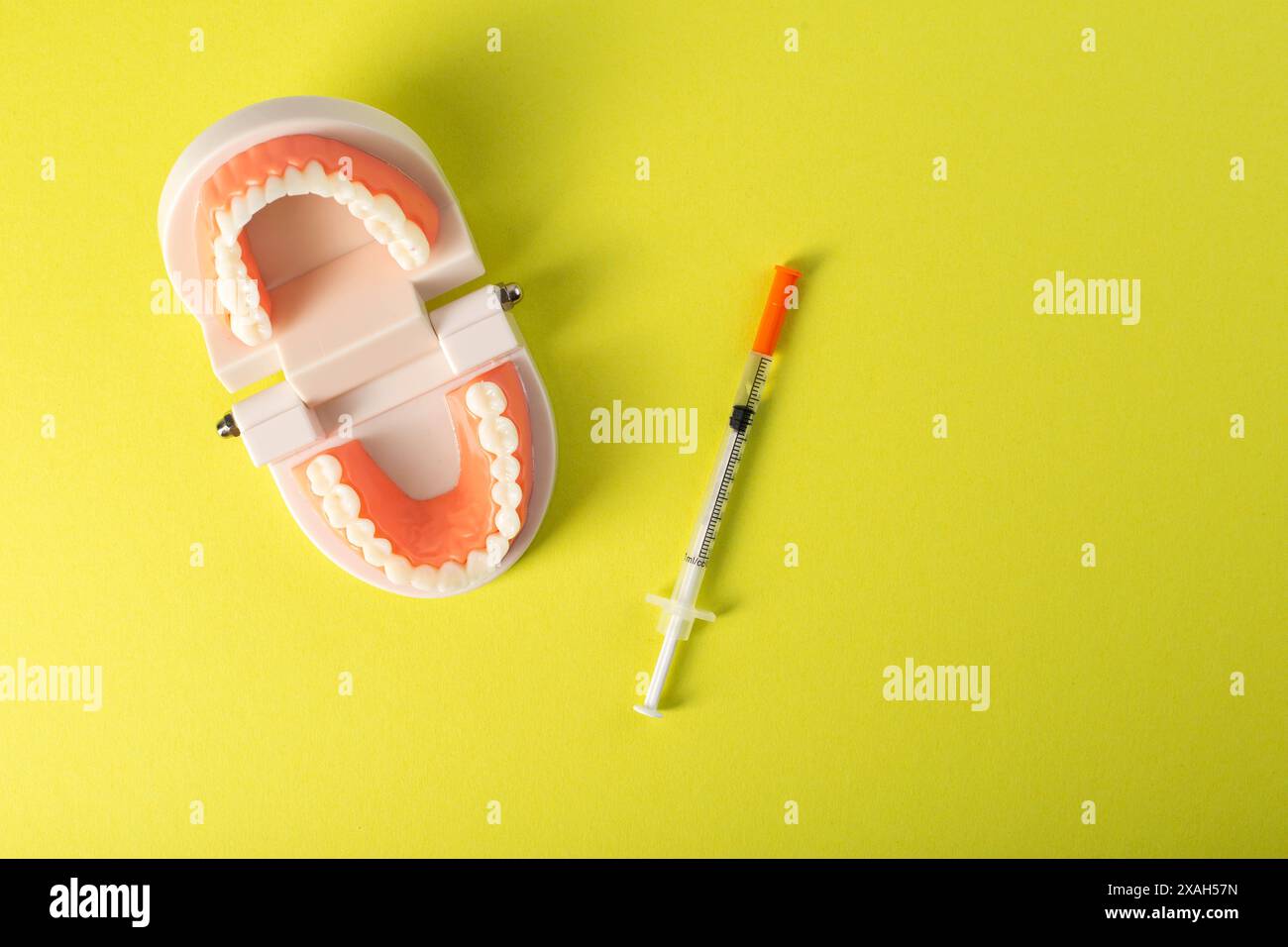 A syringe with anesthesia on a yellow background next to a mock-up of a ...