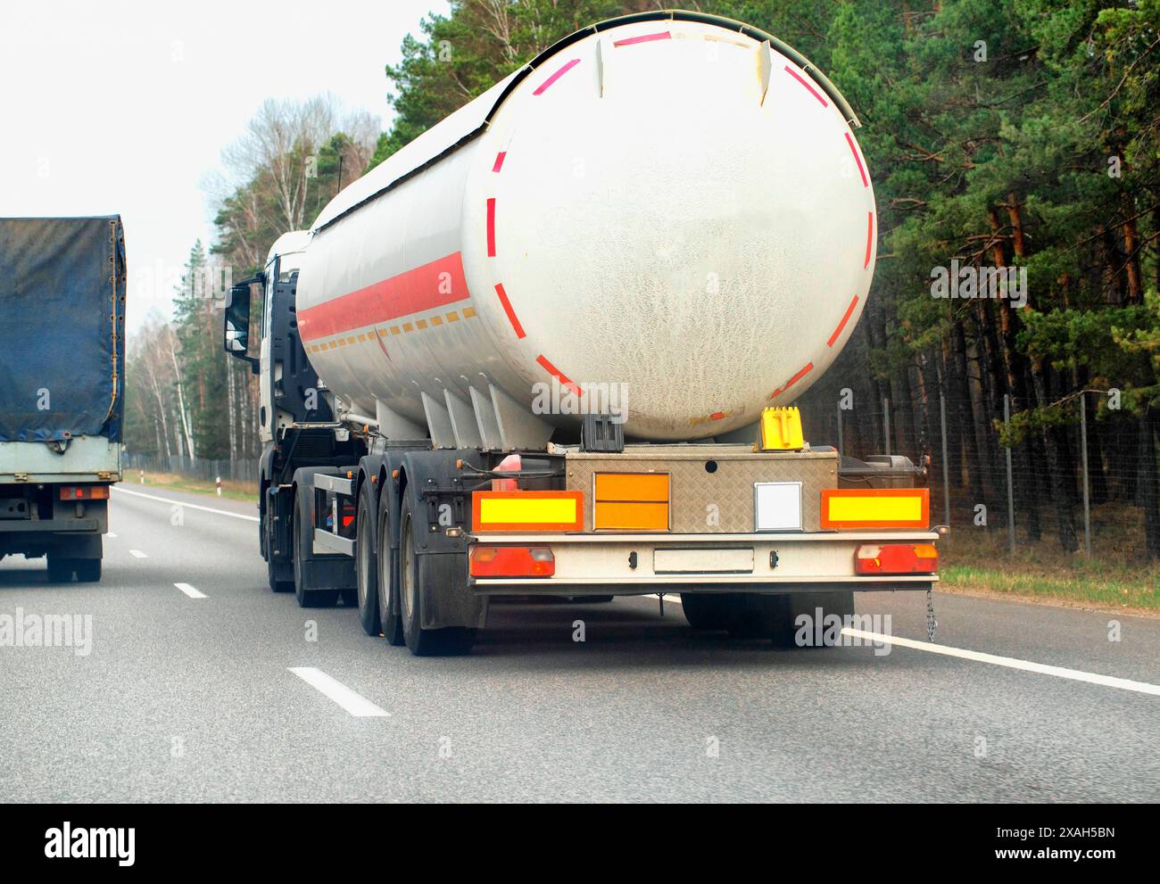 A truck with a semi-trailer tanker transports a dangerous chemical ...