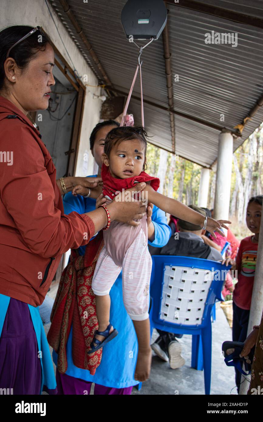 Weighing children on a hanging scale Samudayik Swastha Ikai, a ...