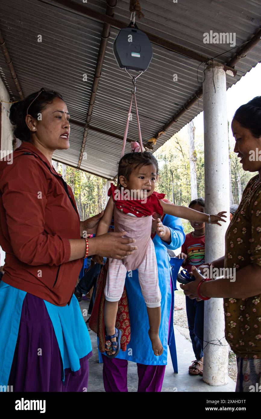 Weighing children on a hanging scale Samudayik Swastha Ikai, a ...