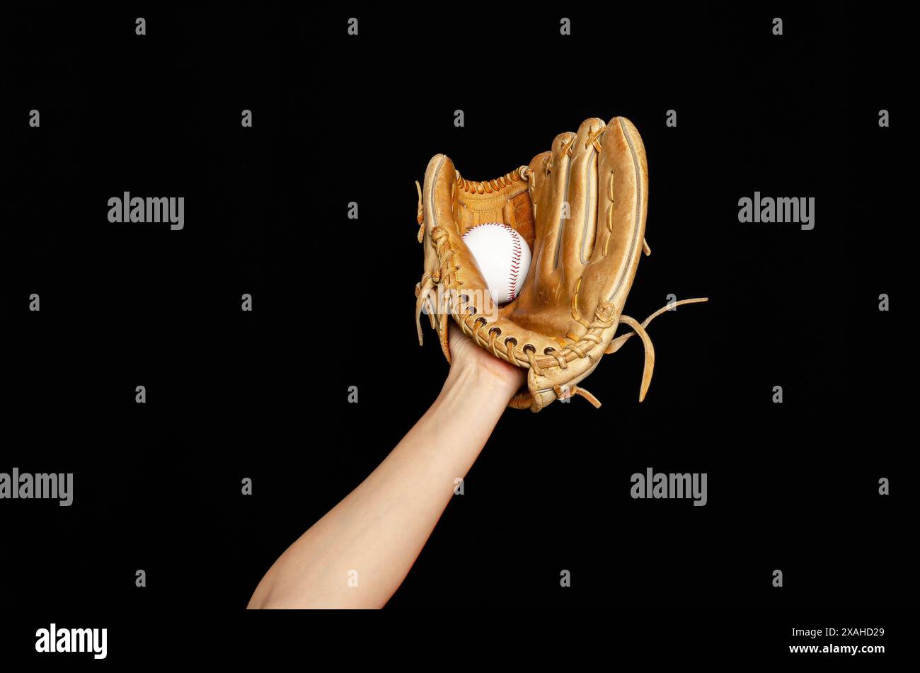 Hand in brown leather baseball glove catches ball. Black background ...