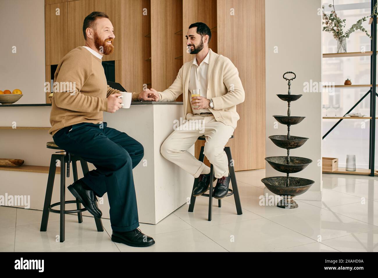 Two men, a happy gay couple, engage in conversation while seated on ...