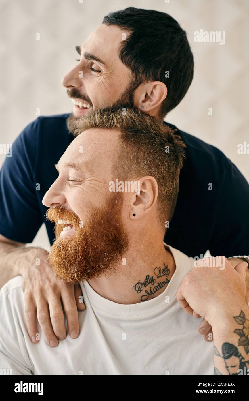 Two men, with tattoos on their arms, share a warm hug in a display of ...