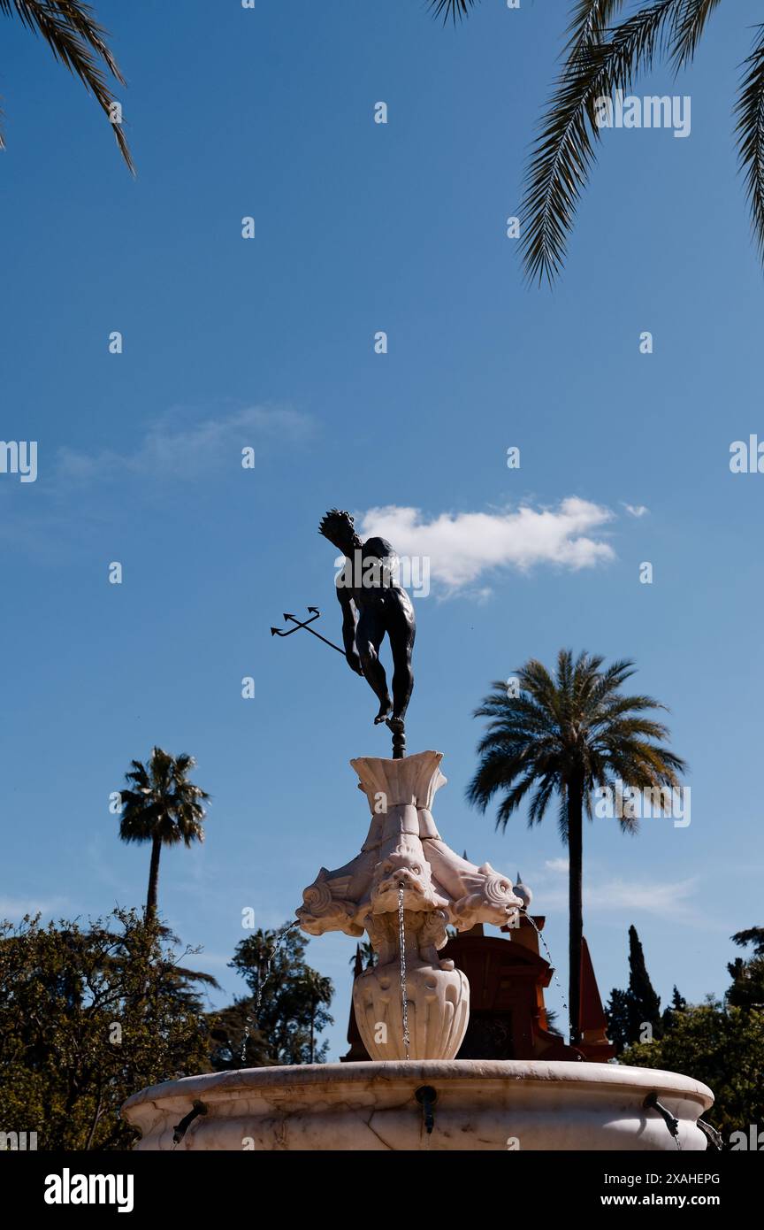 A striking statue of Neptune atop a fountain stands against a clear ...