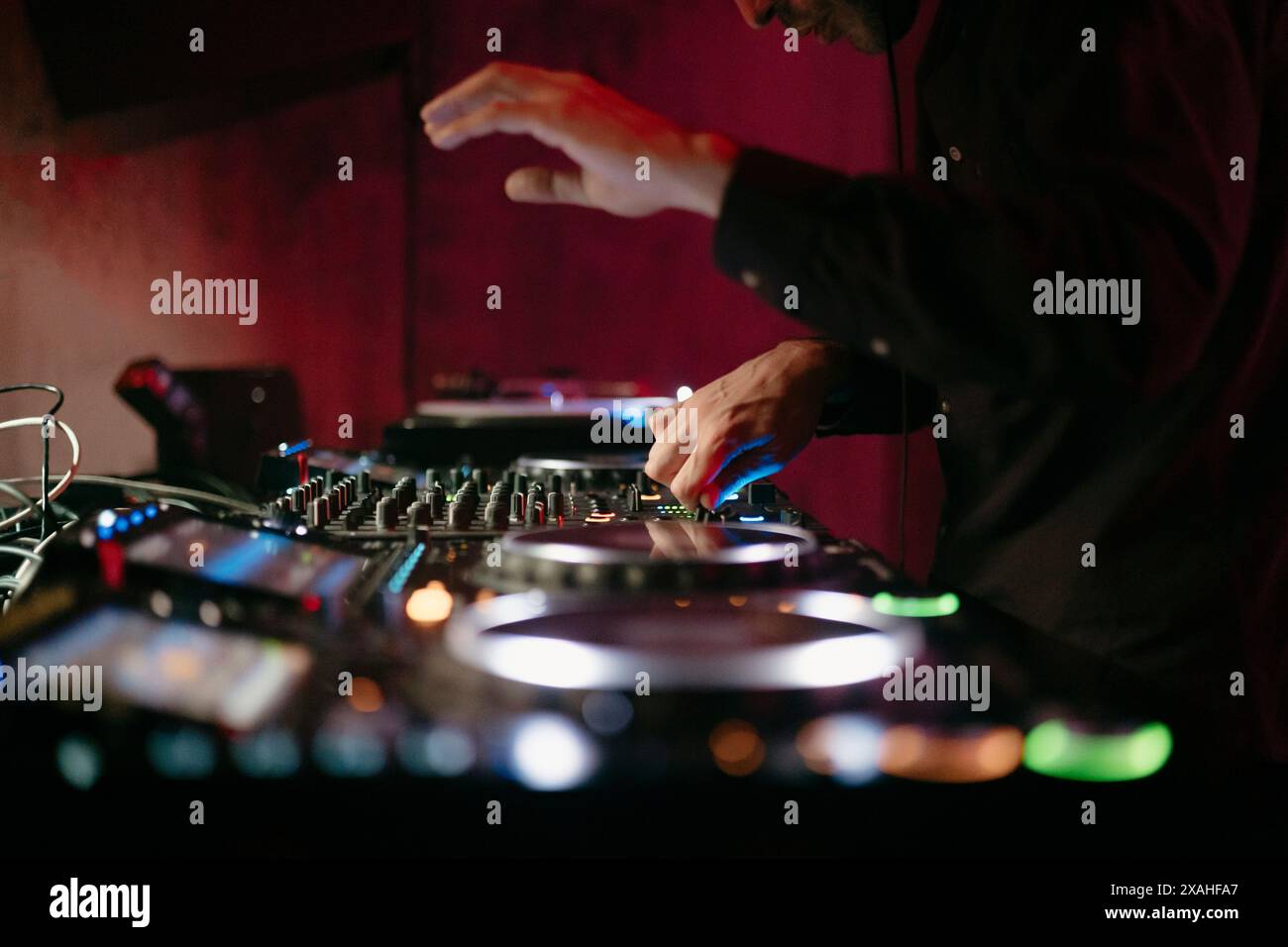 Close up view of a dj's hands playing the mixer while performing Stock ...