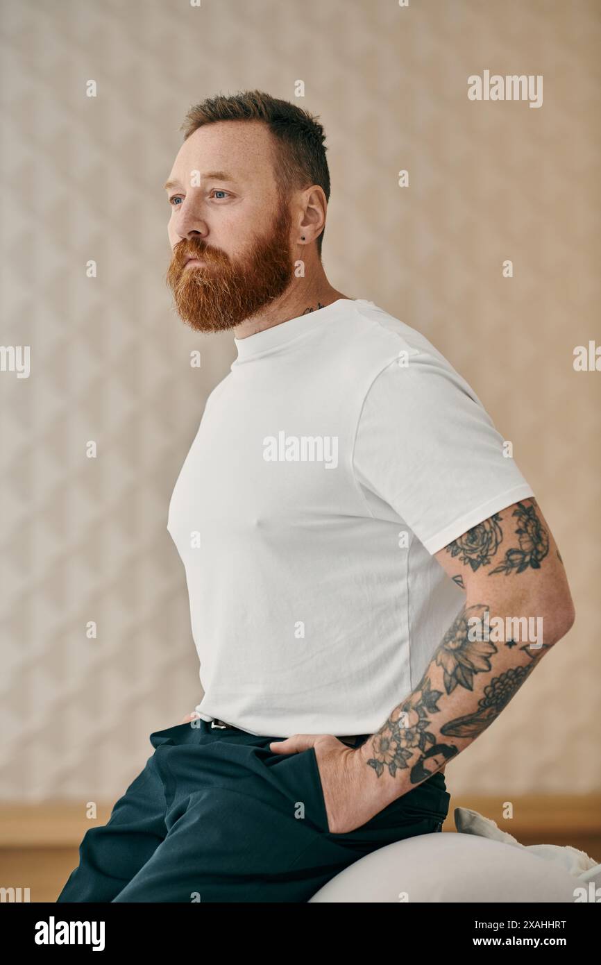 A contented man with a beard sits comfortably, exuding a sense of ...