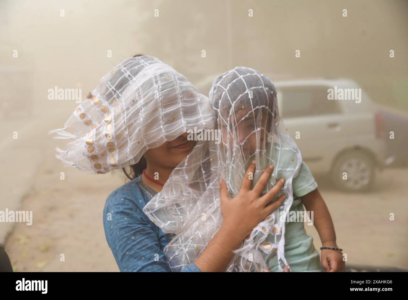 PATNA, INDIA - JUNE 6: A lady covering her child from dupatta during ...