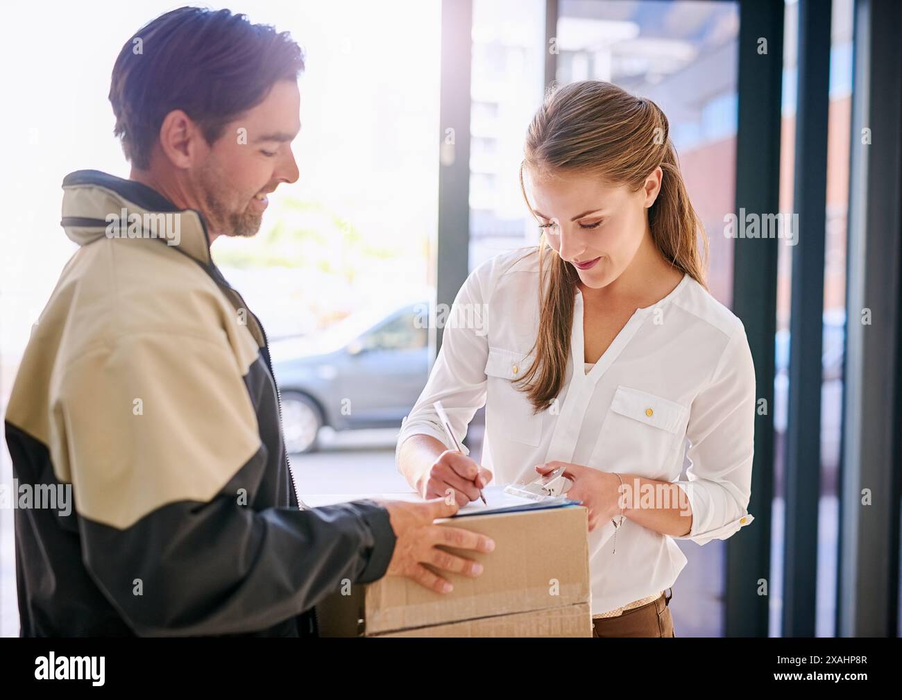 Signing, delivery man and woman with package for courier drop off with ...