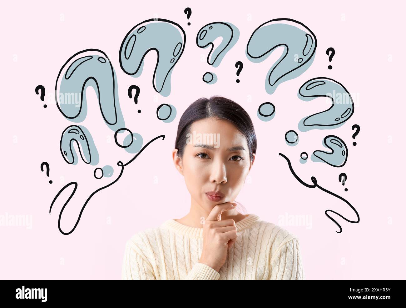 Portrait of thoughtful young Asian woman and drawn question marks on ...