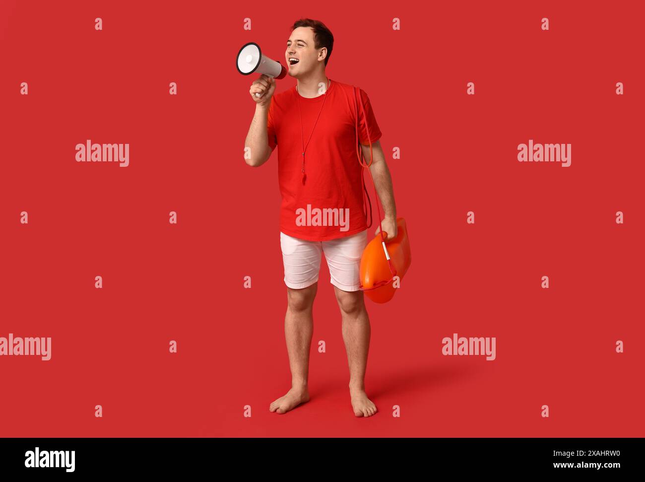 Male lifeguard with rescue tube buoy and megaphone on red background ...
