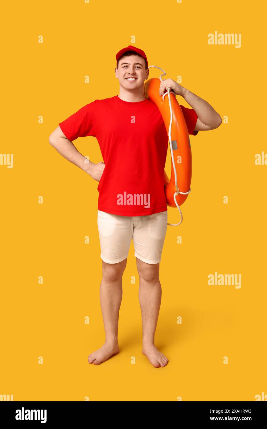 Portrait of male lifeguard with ring buoy on yellow background Stock ...