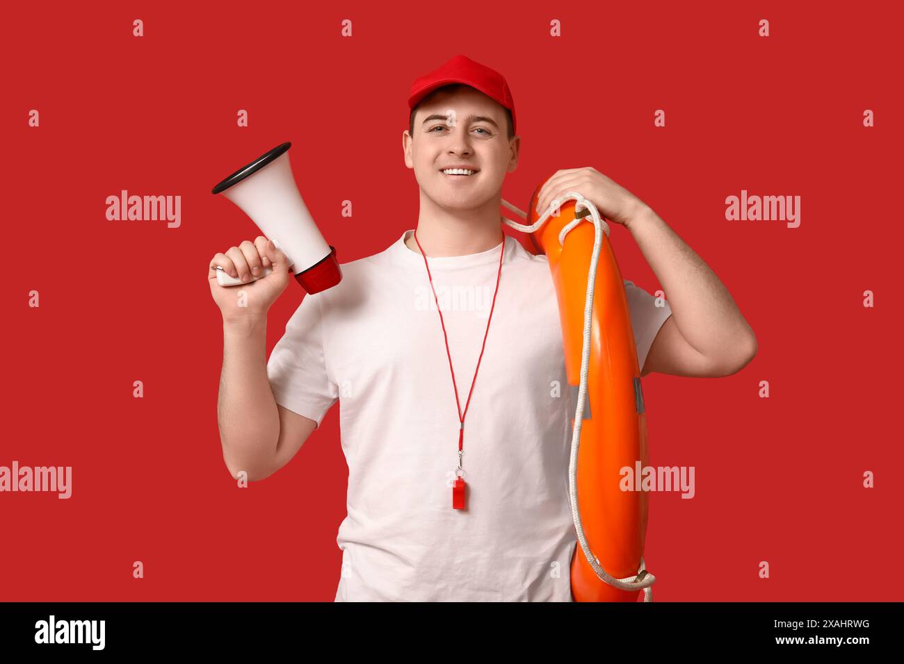 Portrait of male lifeguard with ring buoy and megaphone on red ...
