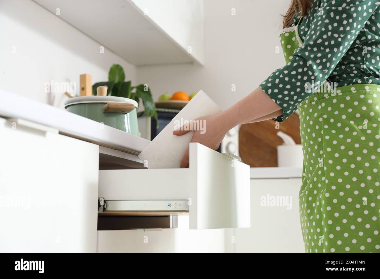 Housewife taking roll of paper towels from drawer in kitchen, closeup ...