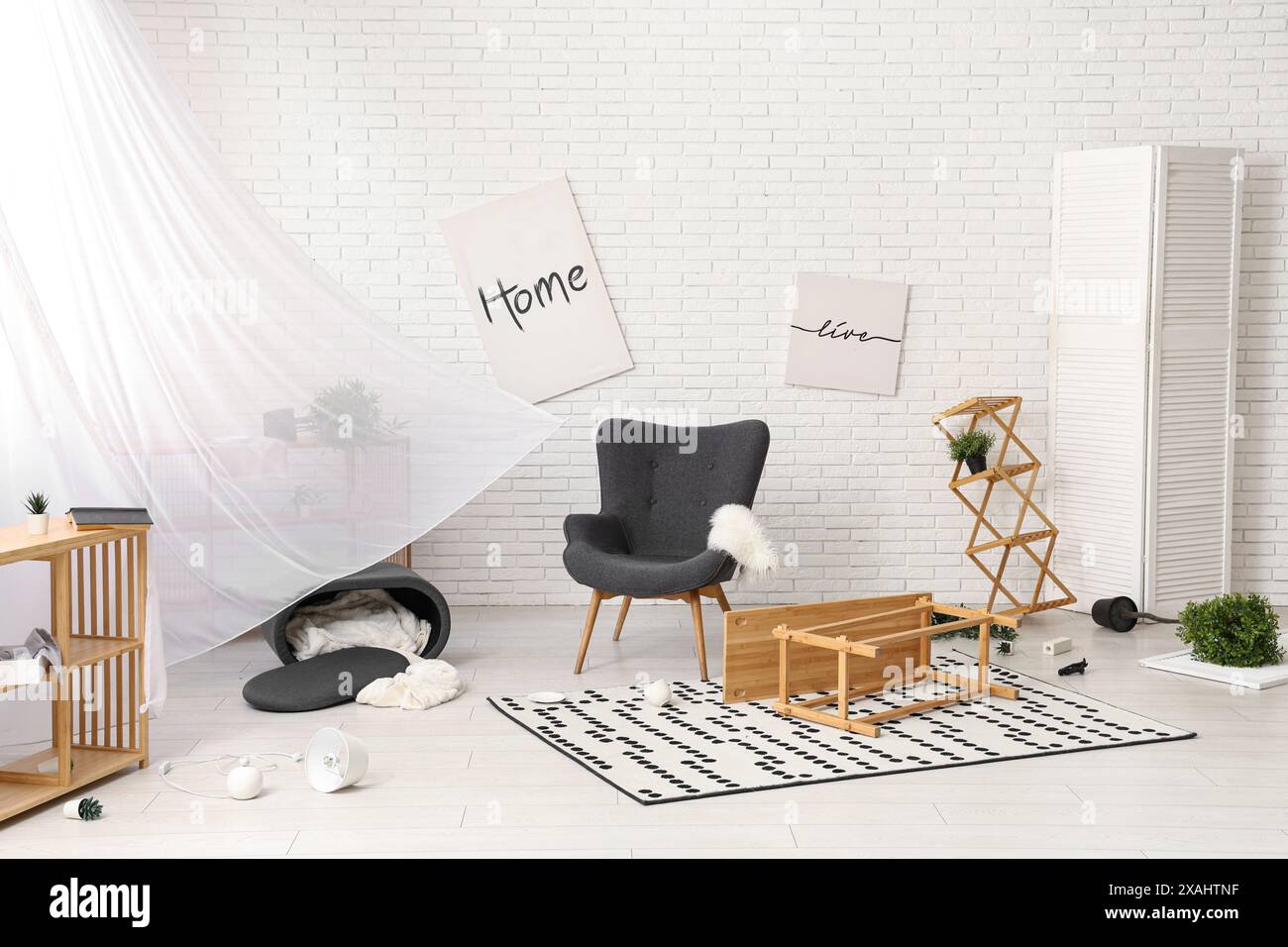 Interior of messy living room with armchair and overturned coffee table ...
