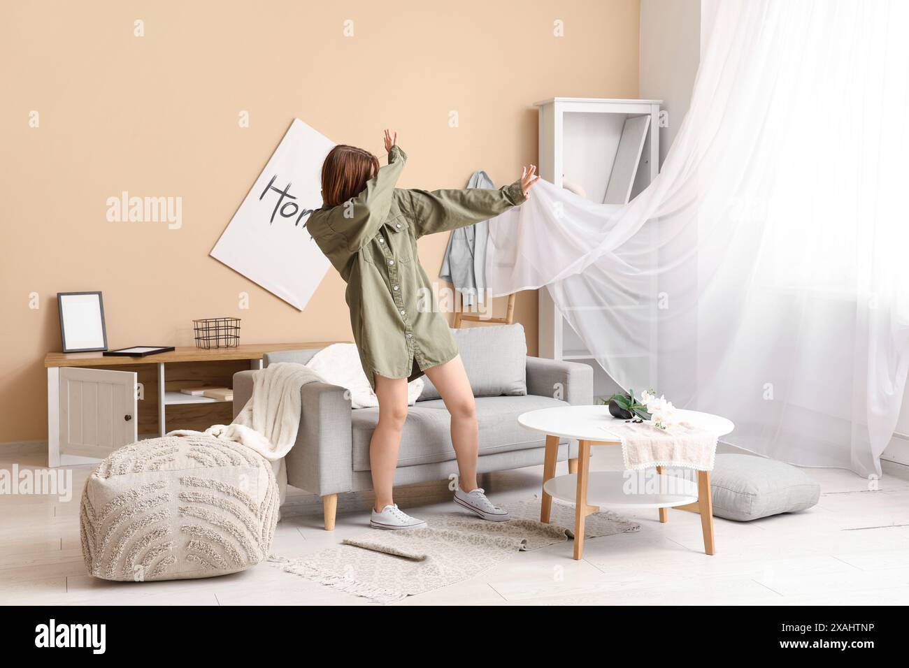 Scared woman during earthquake at home Stock Photo - Alamy