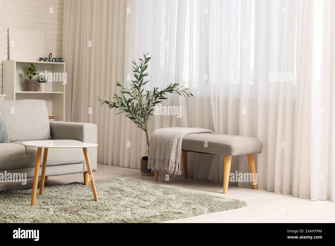 Interior of stylish living room with grey sofa, bench and coffee table ...