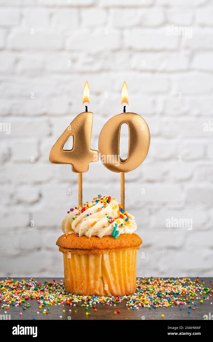 Cupcake with number 40 birthday candle - White block wall background ...