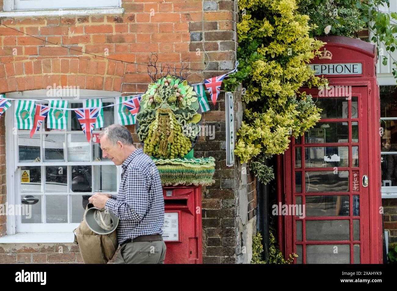 Avebury, UK. 7th June 2024. A knitted Green Man post box topper has ...
