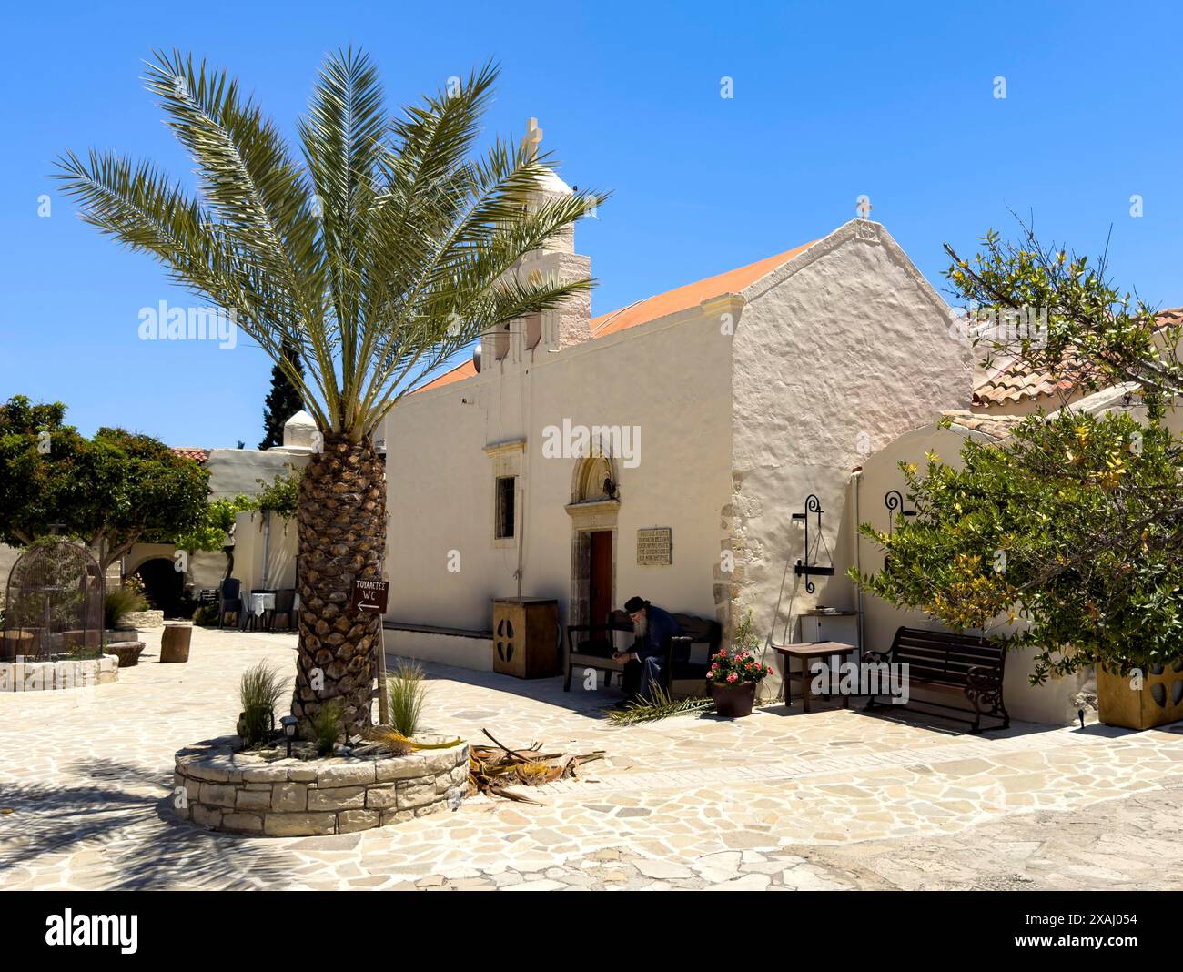 In the foreground cretan date palm (Phoenix theophrasti) behind it two-aisled church Monastery ...