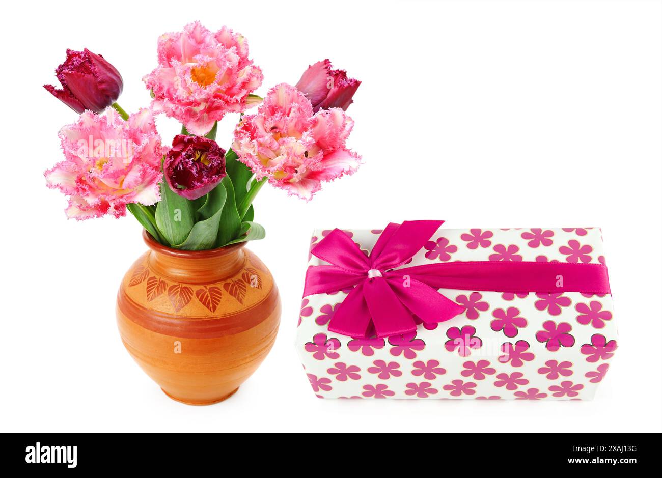A gift in festive packaging and tulips in a vase isolated on white ...