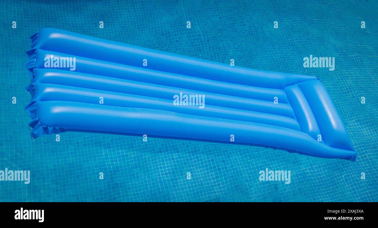 blue inflatable swimming mattress in the pool Stock Photo - Alamy