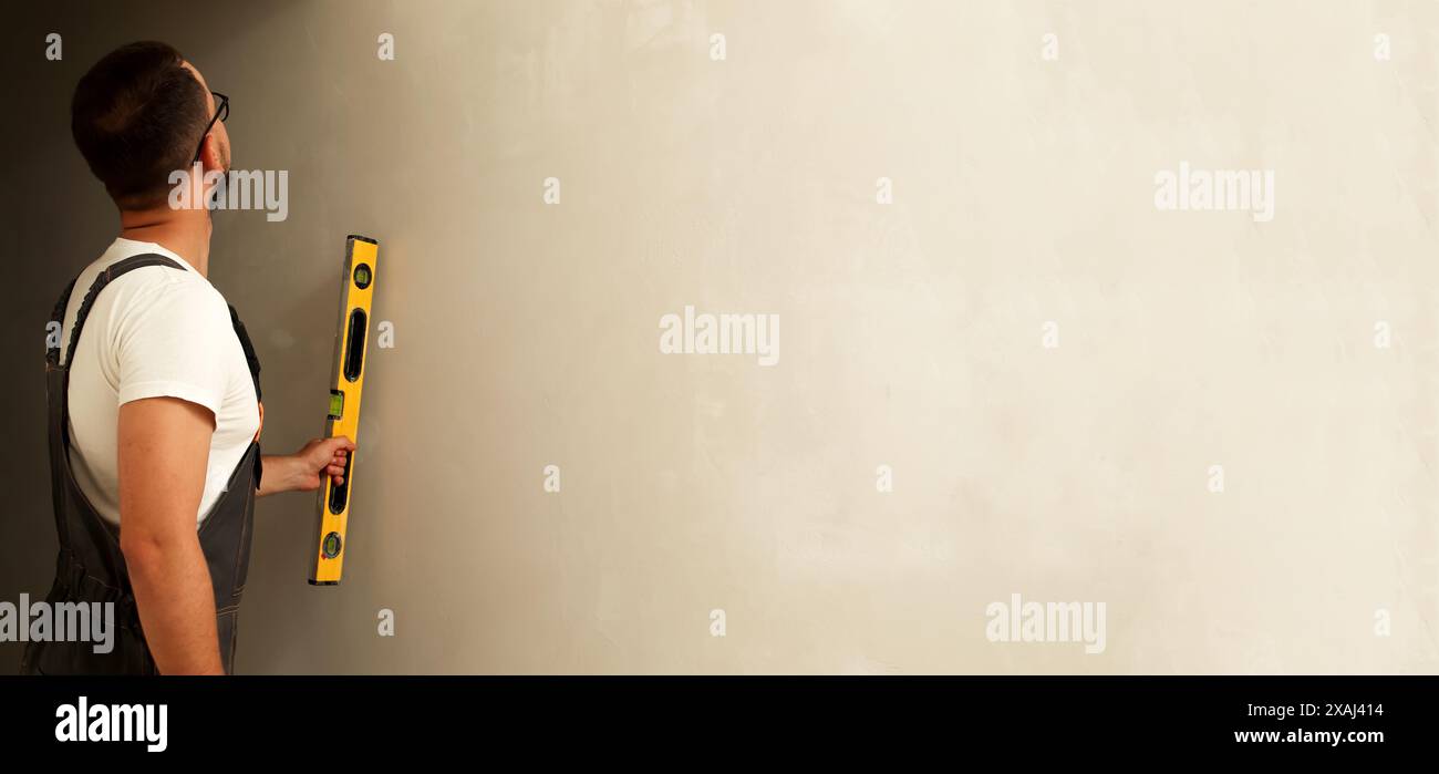 Man using level tool on wall, ample copy space, ideal for banner design ...