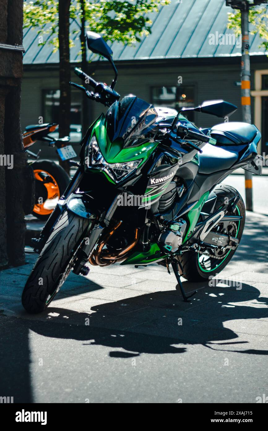 Biker on Motorcycle in the city beside barber shop and buildings Stock ...