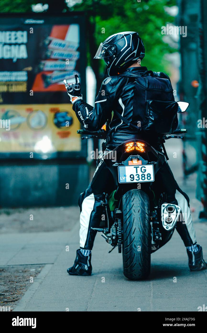 Biker on Motorcycle in the city beside barber shop and buildings Stock ...