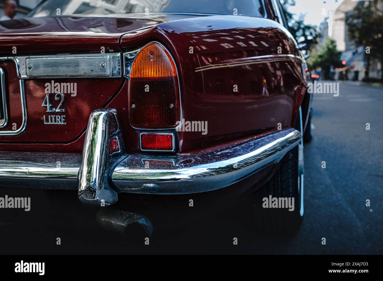 Red old car Jaguar on road in town between buildings Stock Photo - Alamy