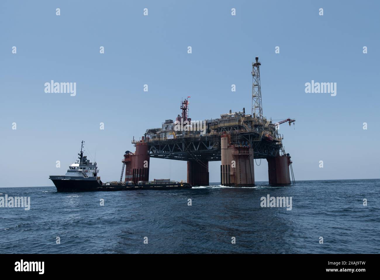 Anglers aboard a fishing boat target tuna near a large floating oil ...