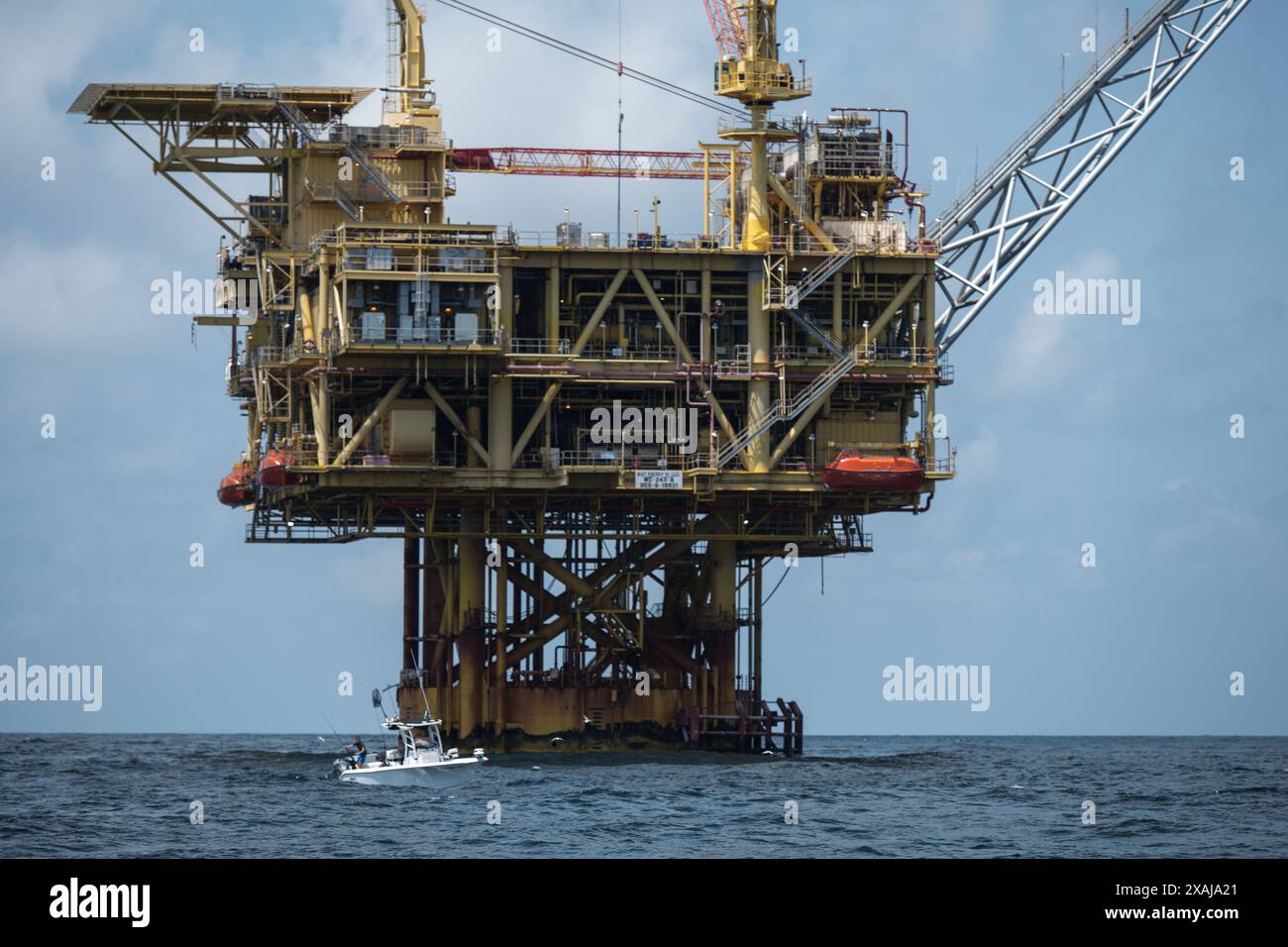 Anglers aboard a fishing boat target tuna near a large floating oil ...